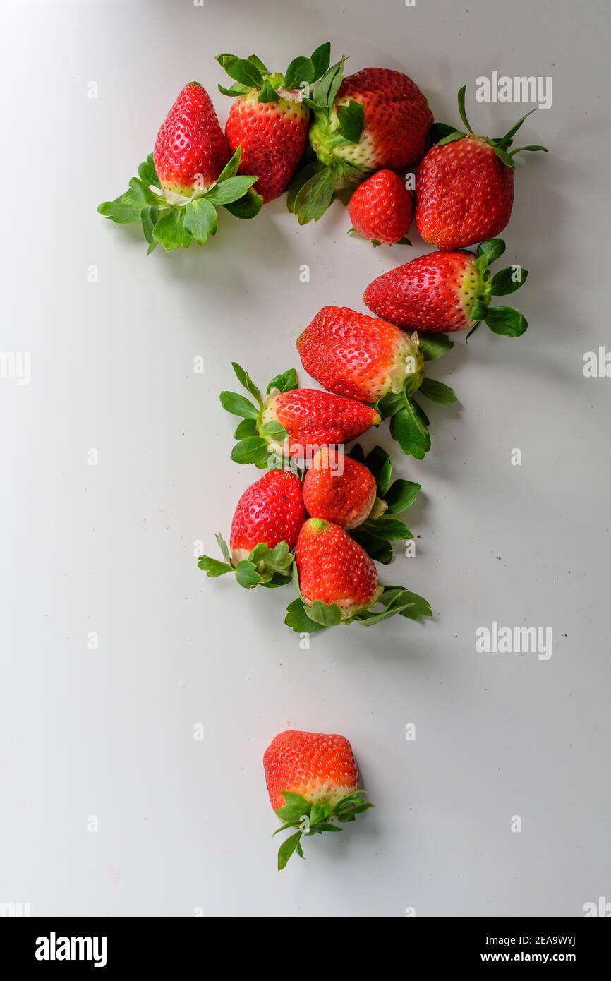 A bunch of bright red strawberries on a white background in the shape ...