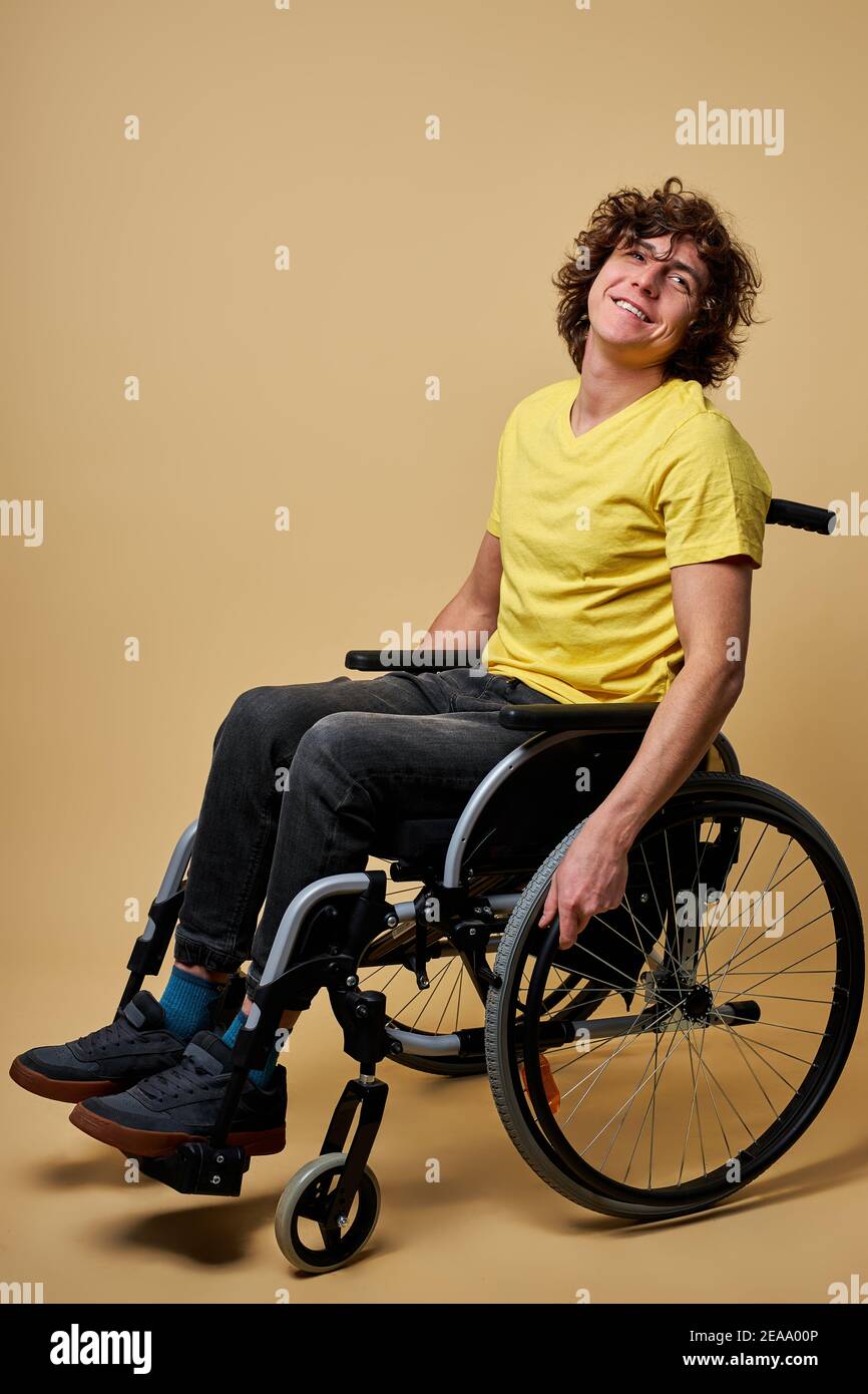 disabled cheerful handicapped man touching wheels and sitting in ...