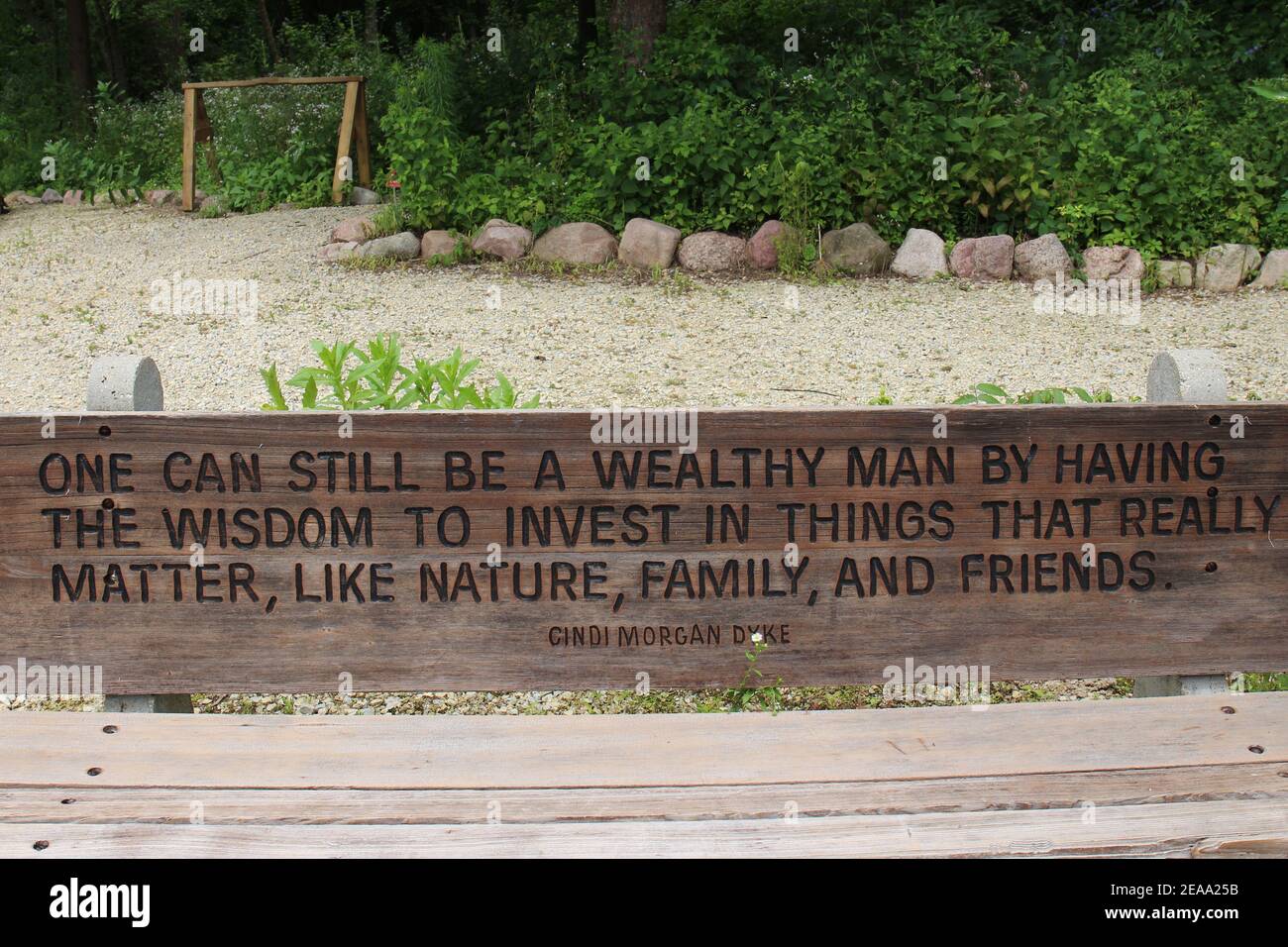A wood park bench with an engraved quote from Cindi Morgan Dyke ...