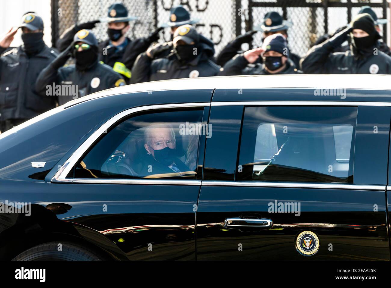 President Joe Biden looks out the window of the presidential limousine ...