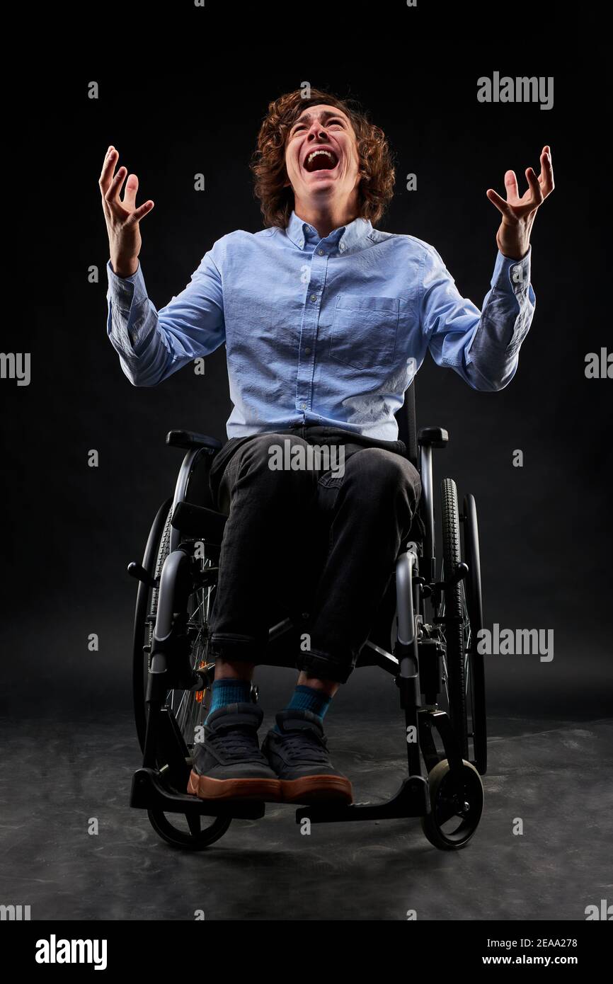 disabled man scream by despair sitting on wheelchair isolated on black ...