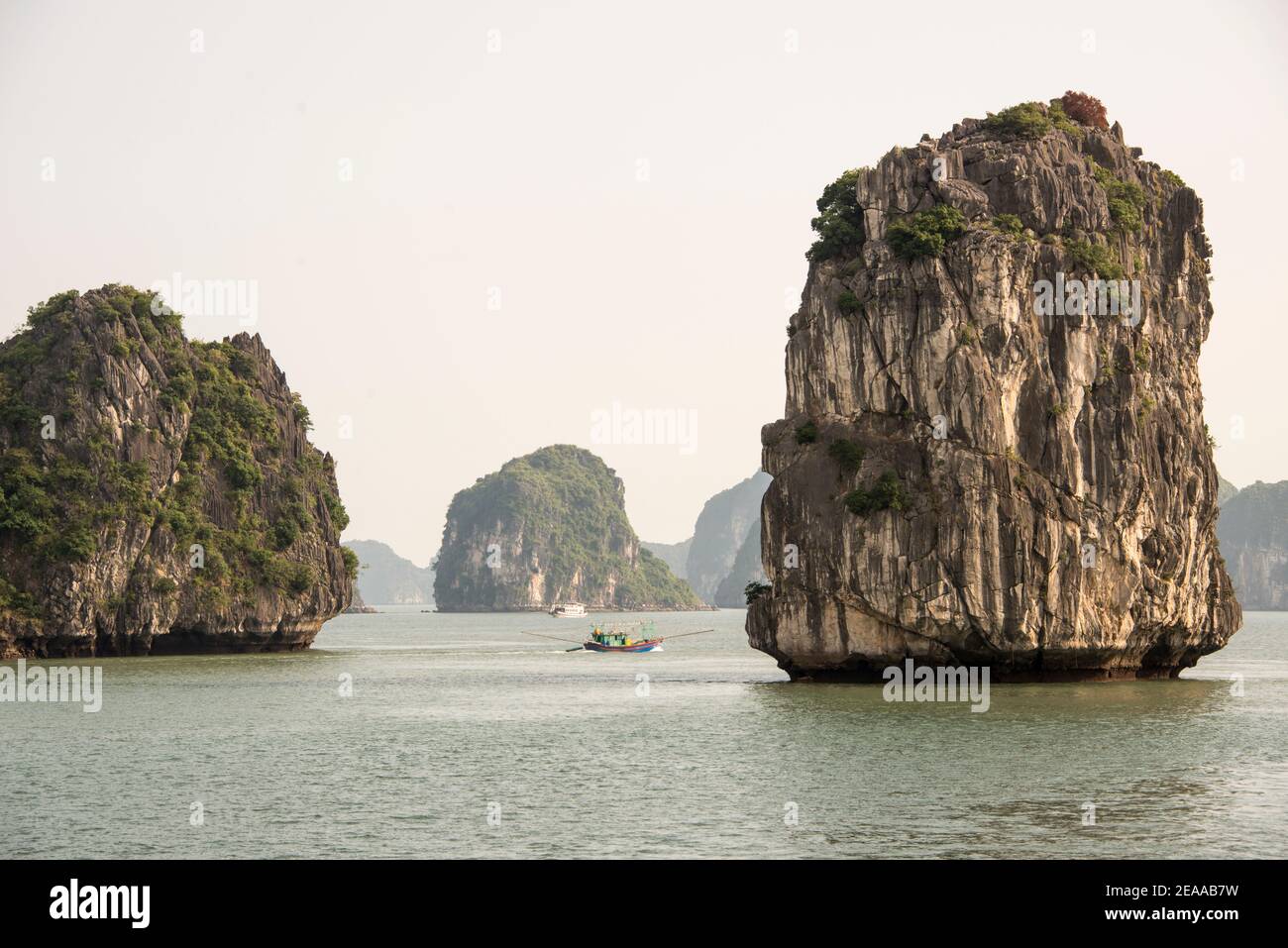 Fishing boat between rocks, Halong Bay, Vietnam Stock Photo - Alamy