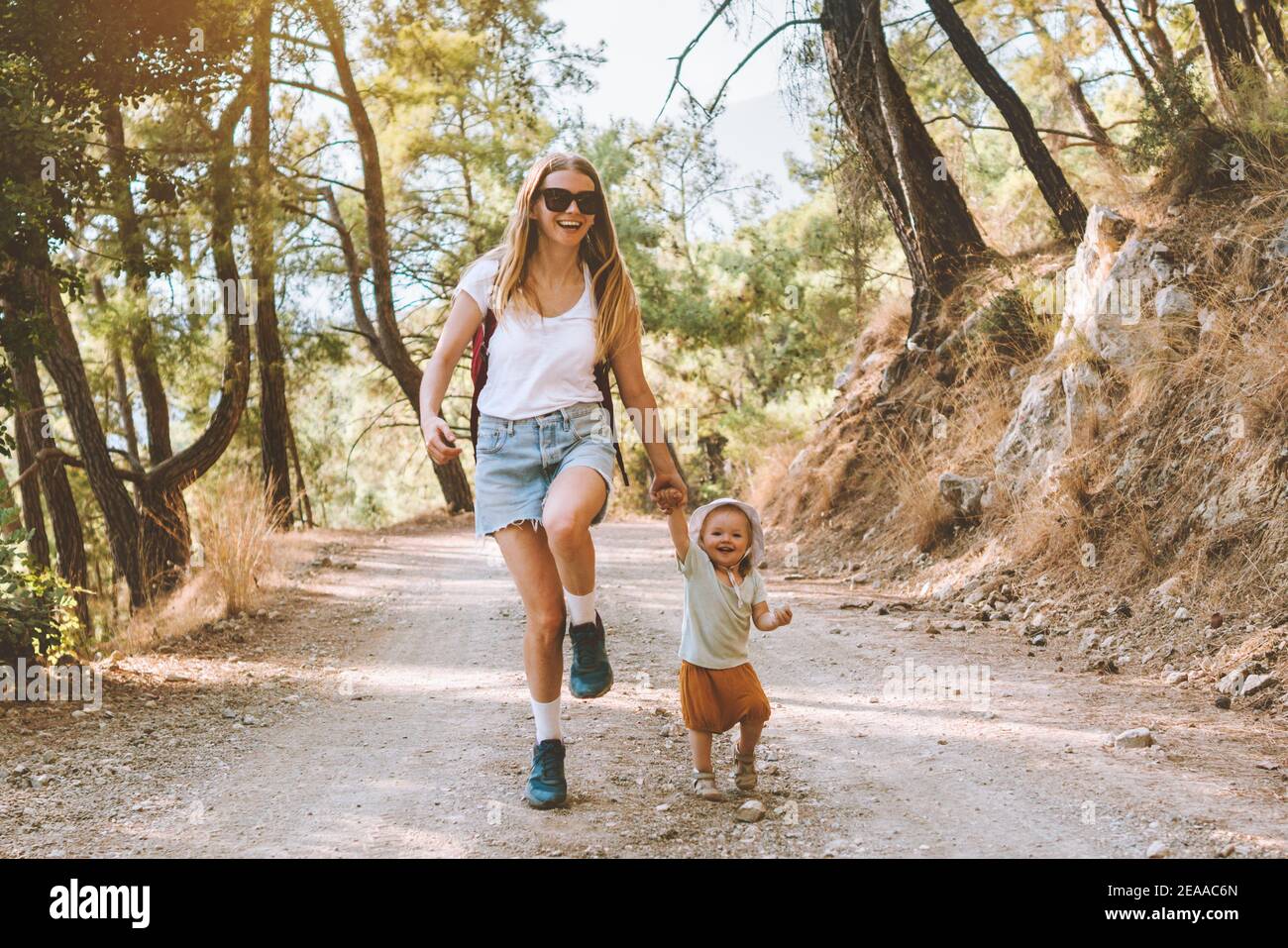 Mother with child daughter walking in forest family vacation mom travel ...