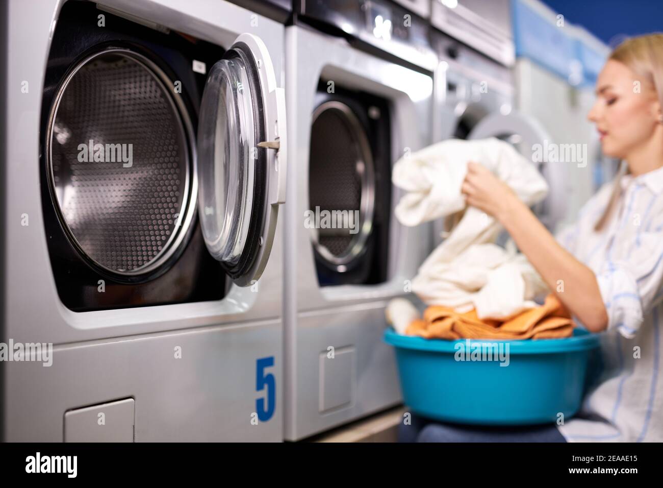 Woman doing the daily chores - laundry. Female folded clean clothes in ...