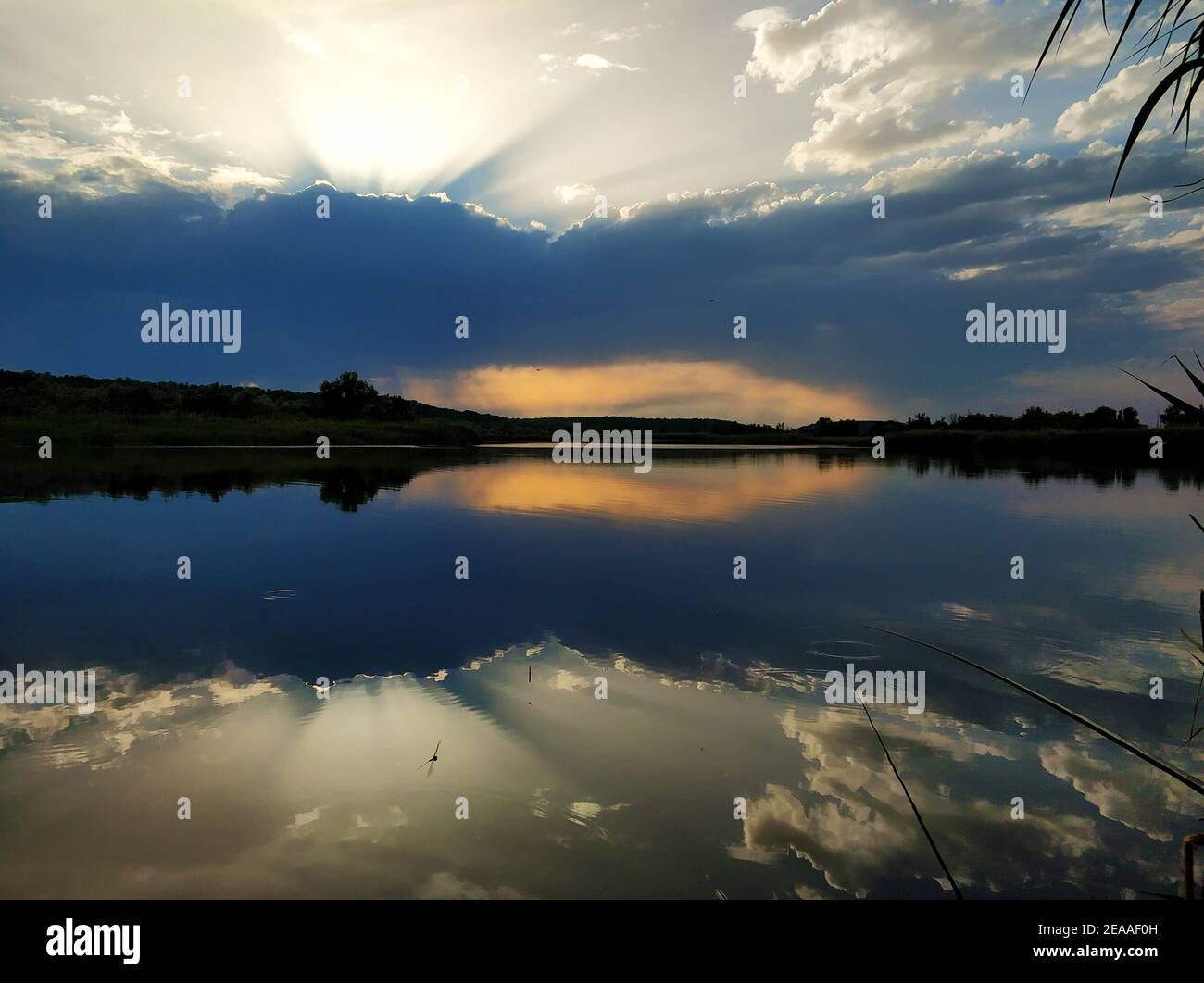 Natural landscape. Sunset over water, reflection of the sun and clouds ...