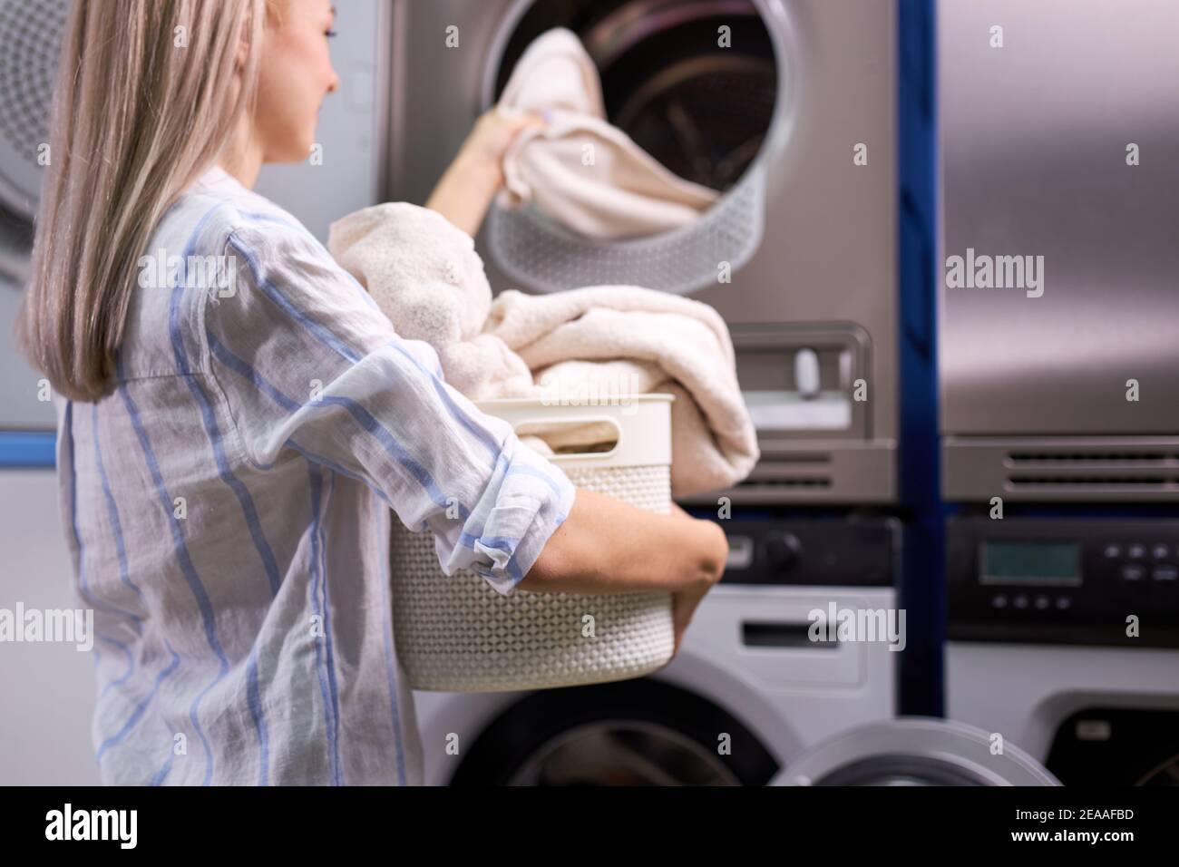 Housework: woman loading clothes into washing machine. caucasian lady ...