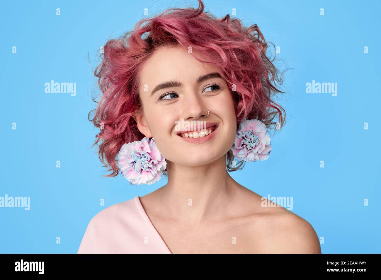 Portrait of young smiling girl with colored curly pink hair, nose ...