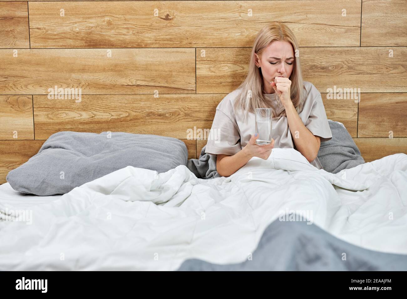 woman has respiratory symptoms fever, coughing, body aches sitting on ...