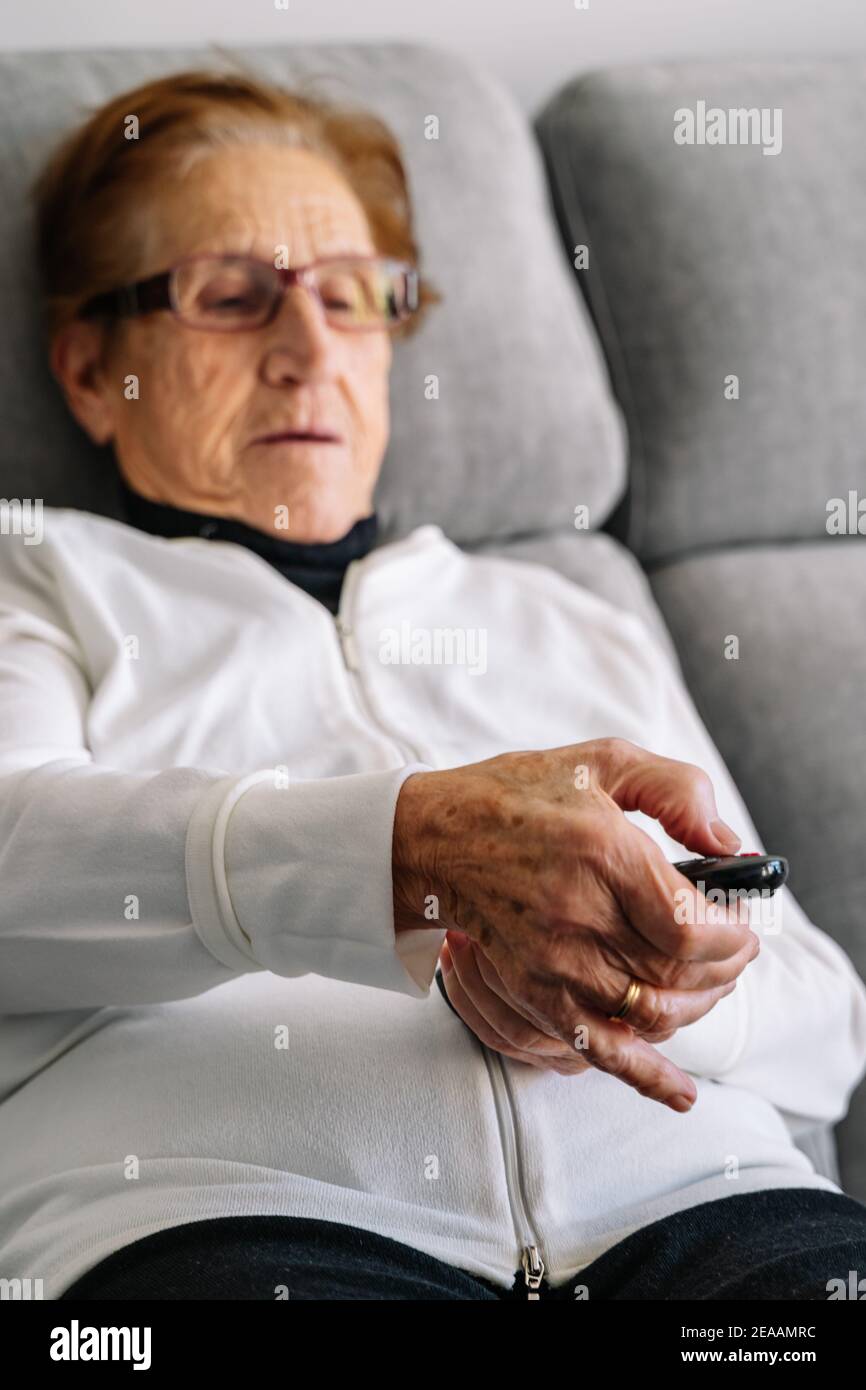 Old grandma changing the channel while watching TV Stock Photo - Alamy