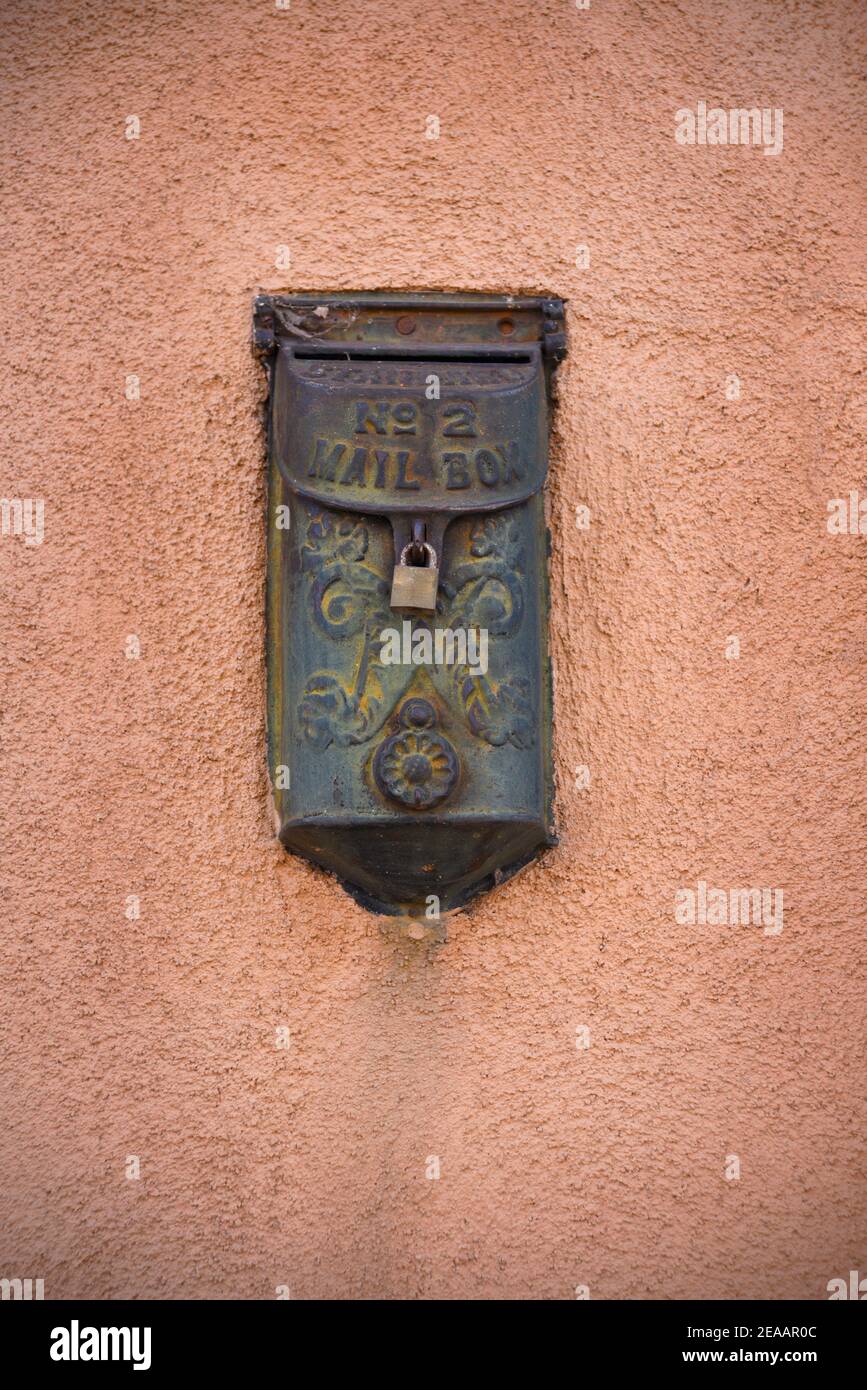 A vintage or antique cast iron mailbox on the side of an art gallery ...