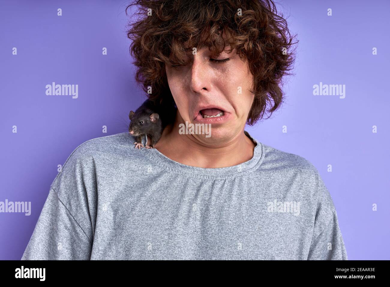 funny man at a loss, does not know what to do with a rat on his t-shirt ...