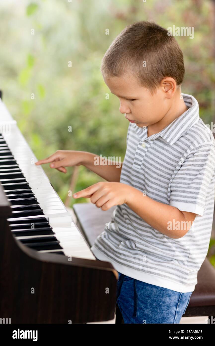 Cute lttle boy playing piano outdoor Stock Photo - Alamy