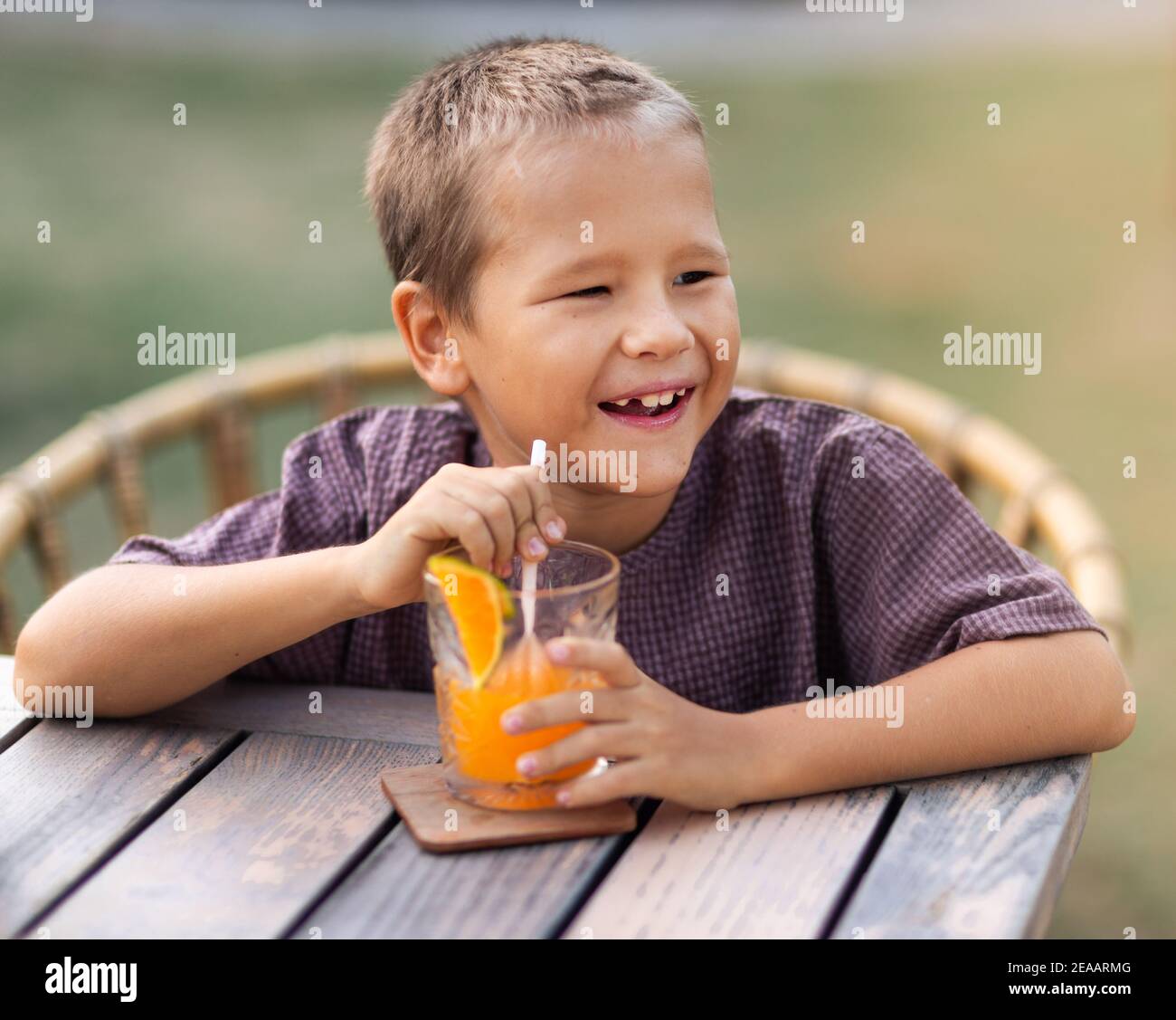 Cute boy drinking juice in outdoor cafe Stock Photo - Alamy
