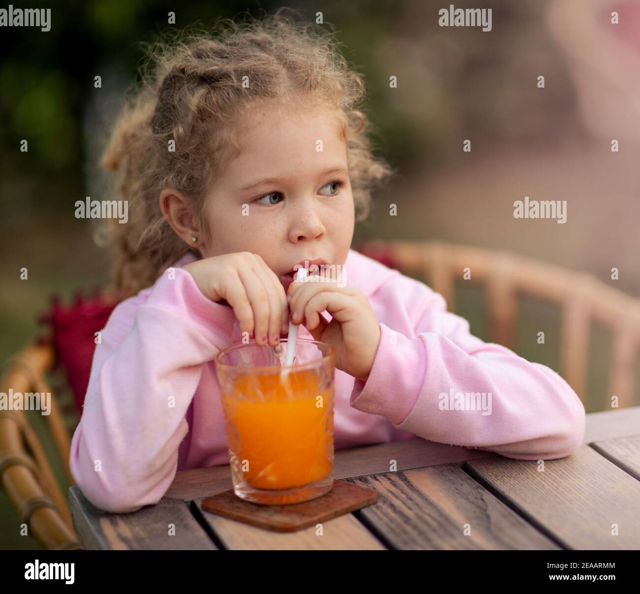 Cute girl drinking juice in outdoor cafe Stock Photo - Alamy