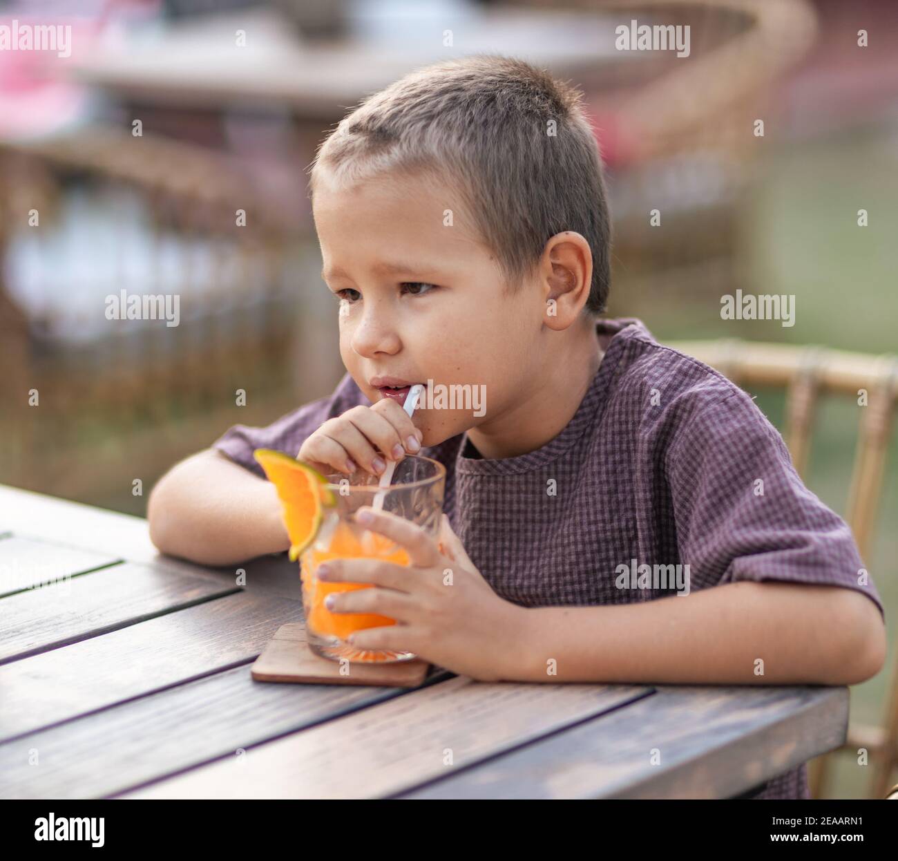 Cute boy drinking juice in outdoor cafe Stock Photo - Alamy
