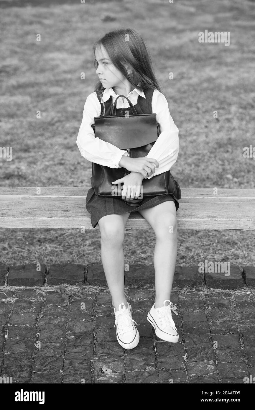 Early learning. Little child sit on bench outdoors. Childhood education ...