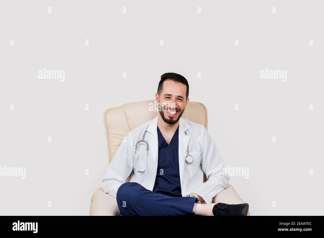 Handsome arab doctor surgeon smiles on white background. Bearded ...