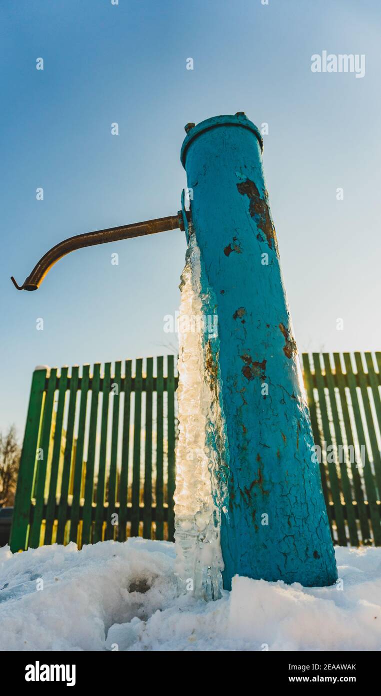 Water froze on the drinking column, water well ice, blue water pump ...