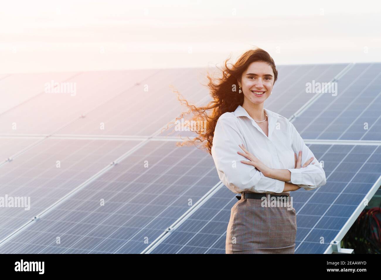 Model with solar panels stands in row on the ground at sunset. Girl ...