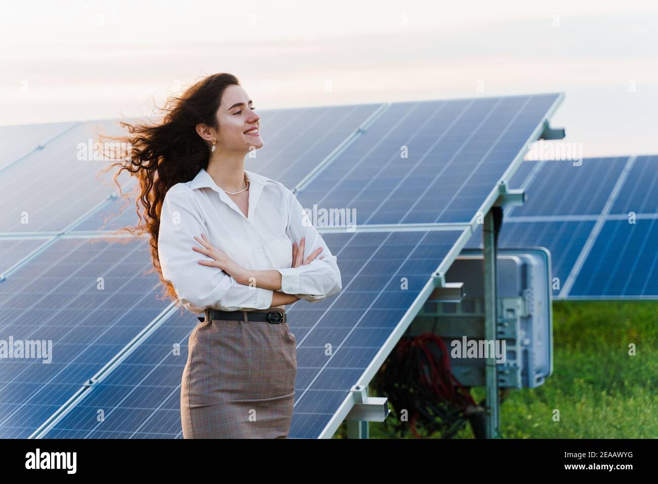 Model with solar panels stands in row on the ground at sunset. Girl ...
