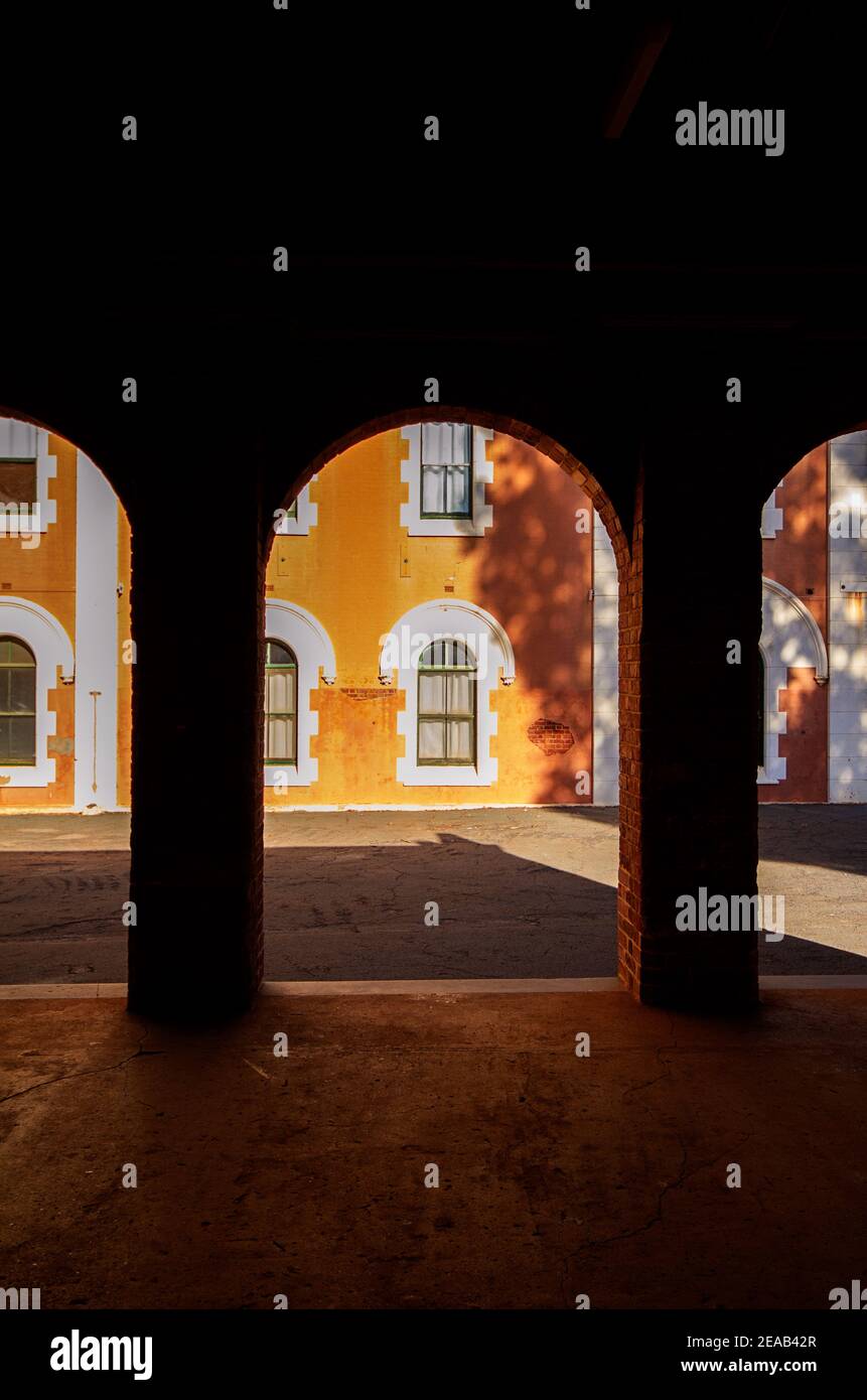 View through stone archways into a courtyard with old buildings Stock ...