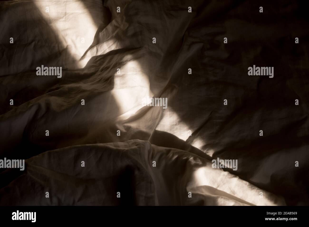 Sunbeam falls on the bed. The sun rays through window in the morning ...