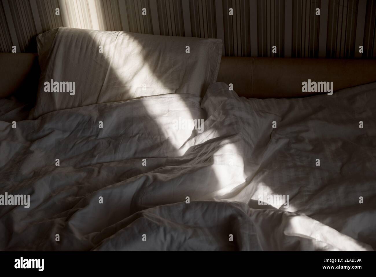 Sunbeam falls on the bed. The sun rays through window in the morning ...