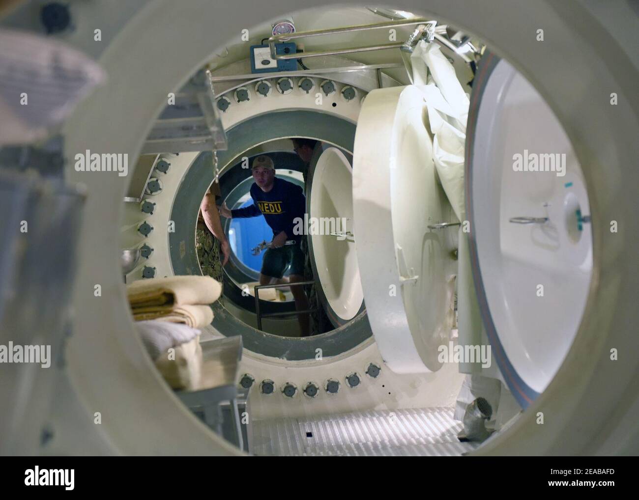 Navy Diver carries some wrenches through the Ocean Simulation Facility ...