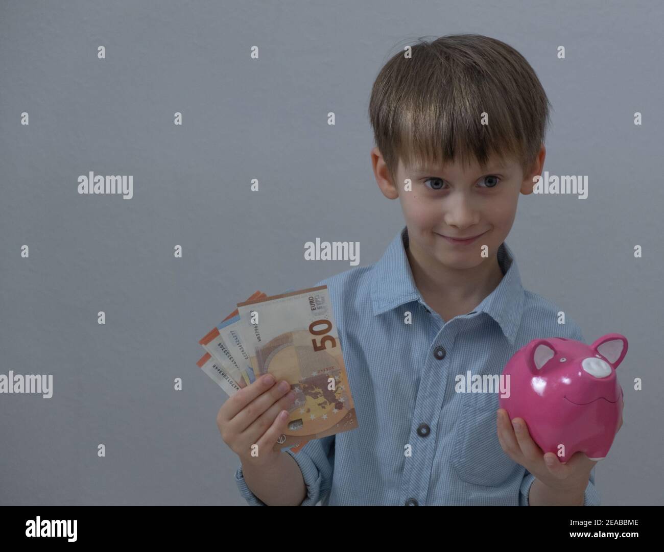 Child Benefit. Boy with banknotes in his hands Stock Photo - Alamy