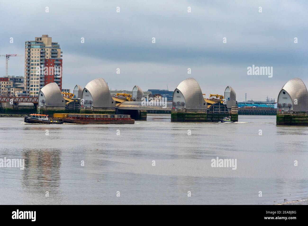 A barge passes through the Thames Barrier from the south bank of the ...