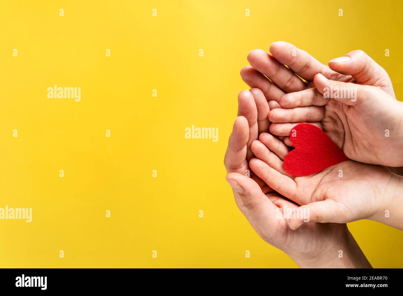 Red hart on palms of mother and son - Caucasian woman and child holding ...