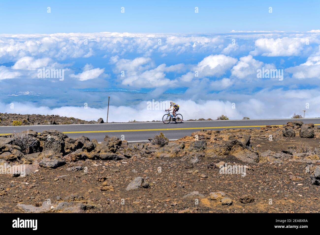 Riding Above Clouds - A female bicyclist riding above the clouds on ...