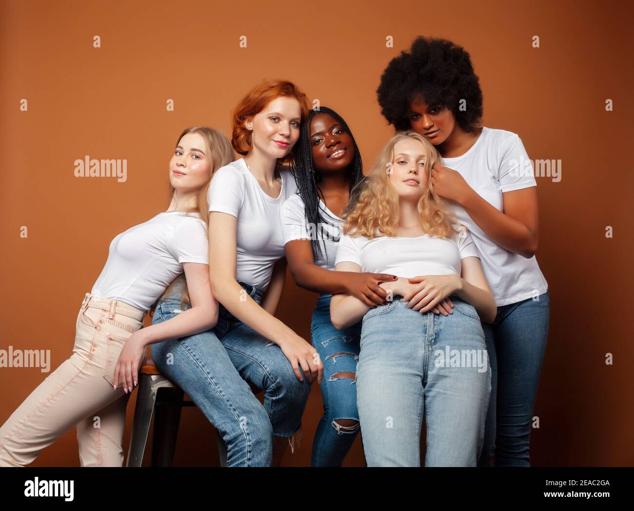 young pretty caucasian, afro, scandinavian woman posing cheerful together on brown background ...