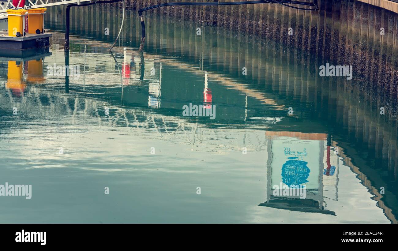 Water reflections at a marina pontoon, signage information rippled in ...