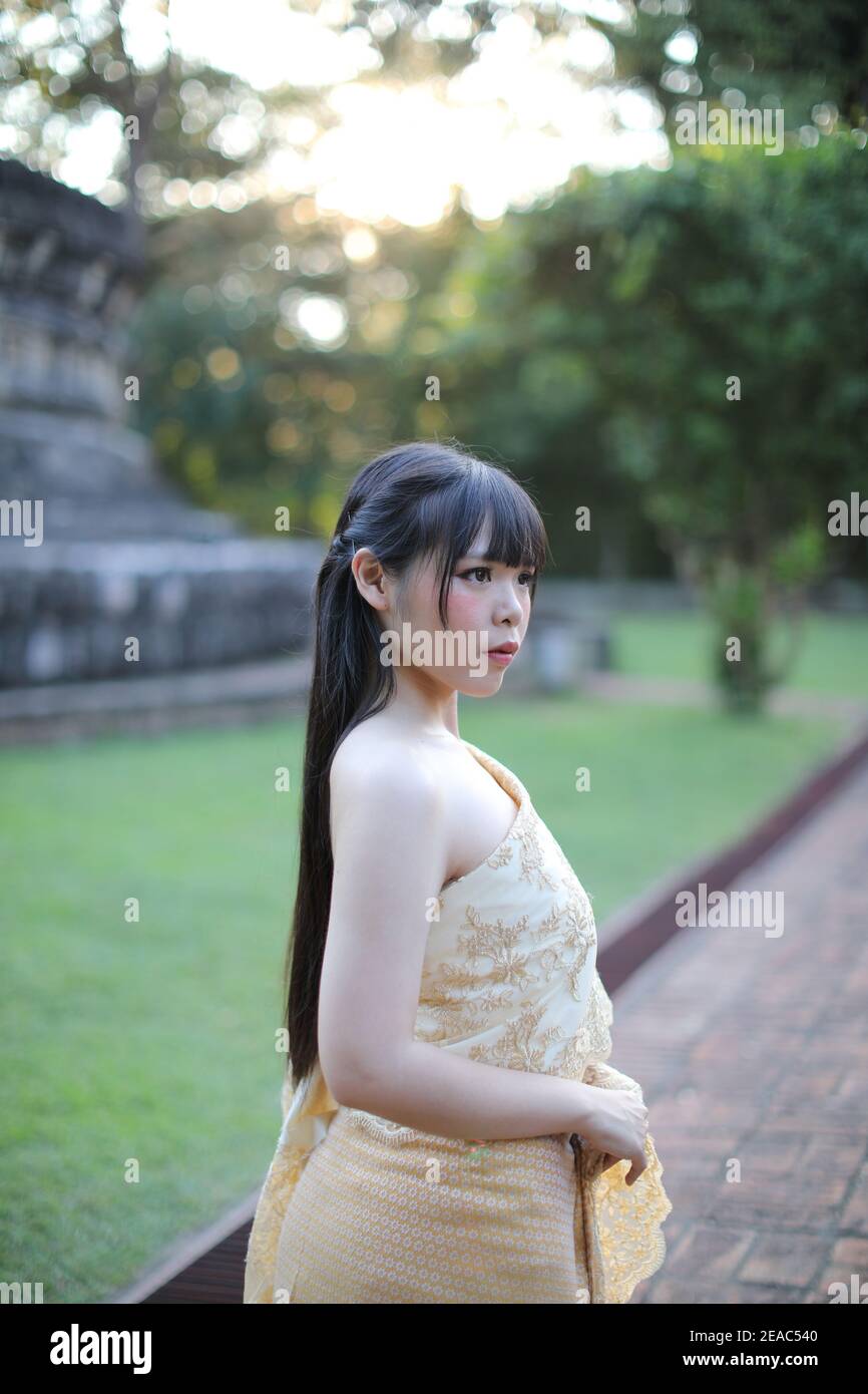 Portrait of Thai female with traditional Thai dress with temple ...