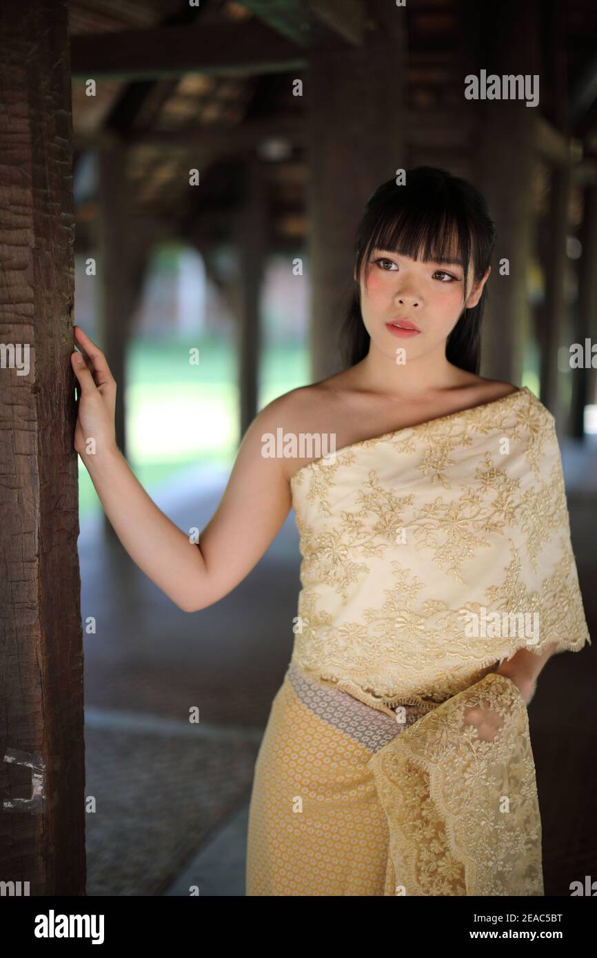 Portrait of Thai female with traditional Thai dress with temple ...