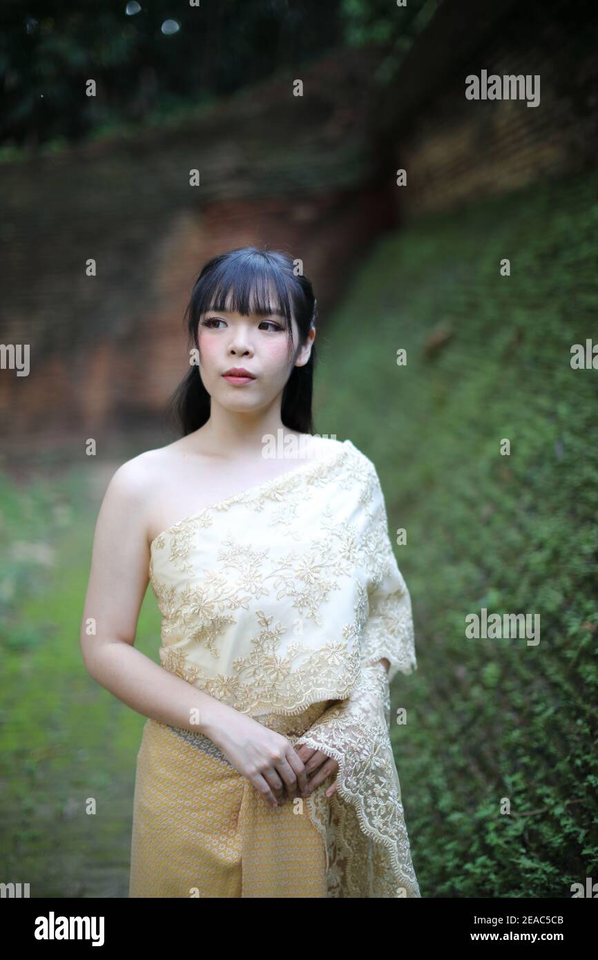 Portrait of Thai female with traditional Thai dress with temple ...