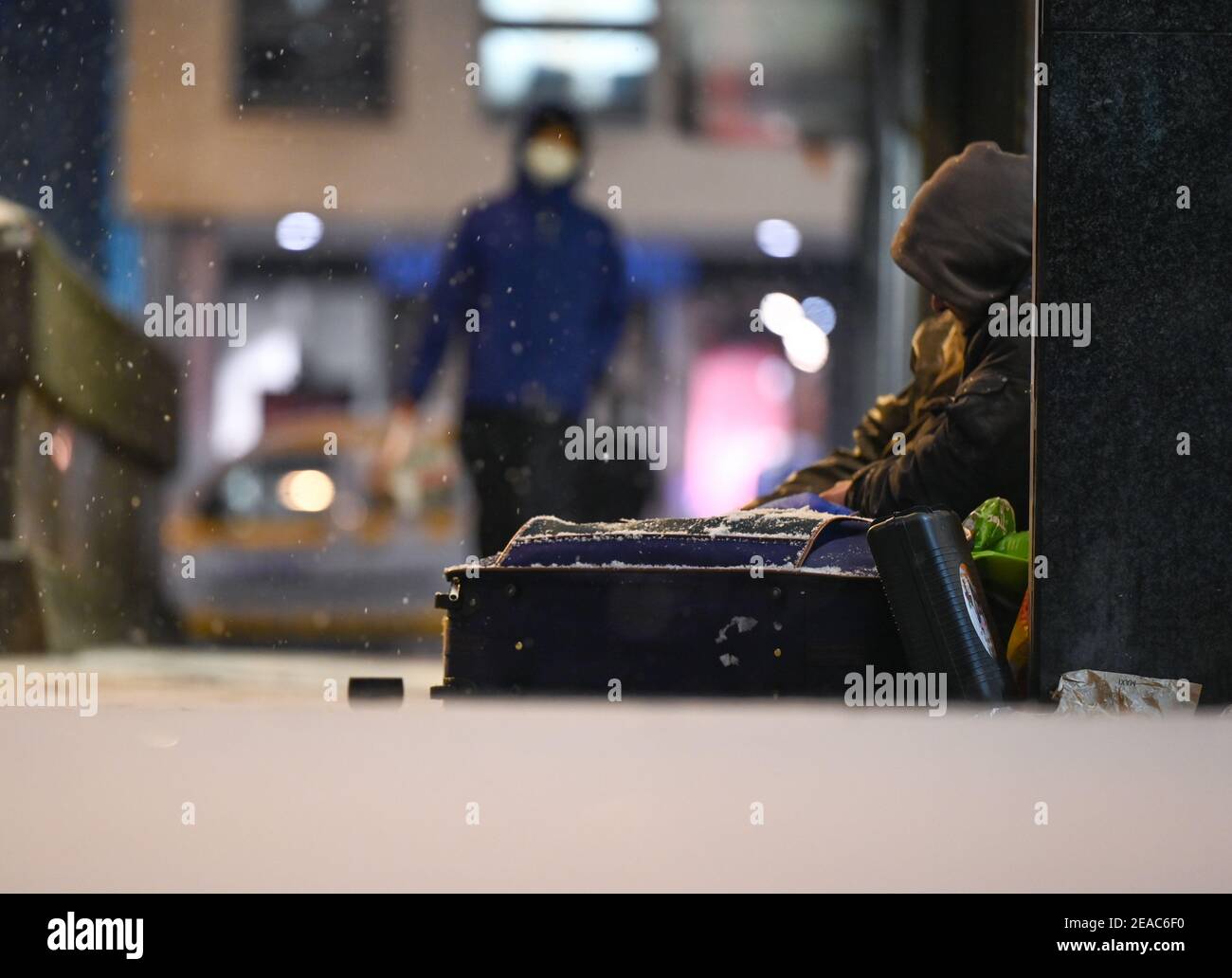 08 February 2021, Hessen, Frankfurt/Main: A homeless man sits with his ...