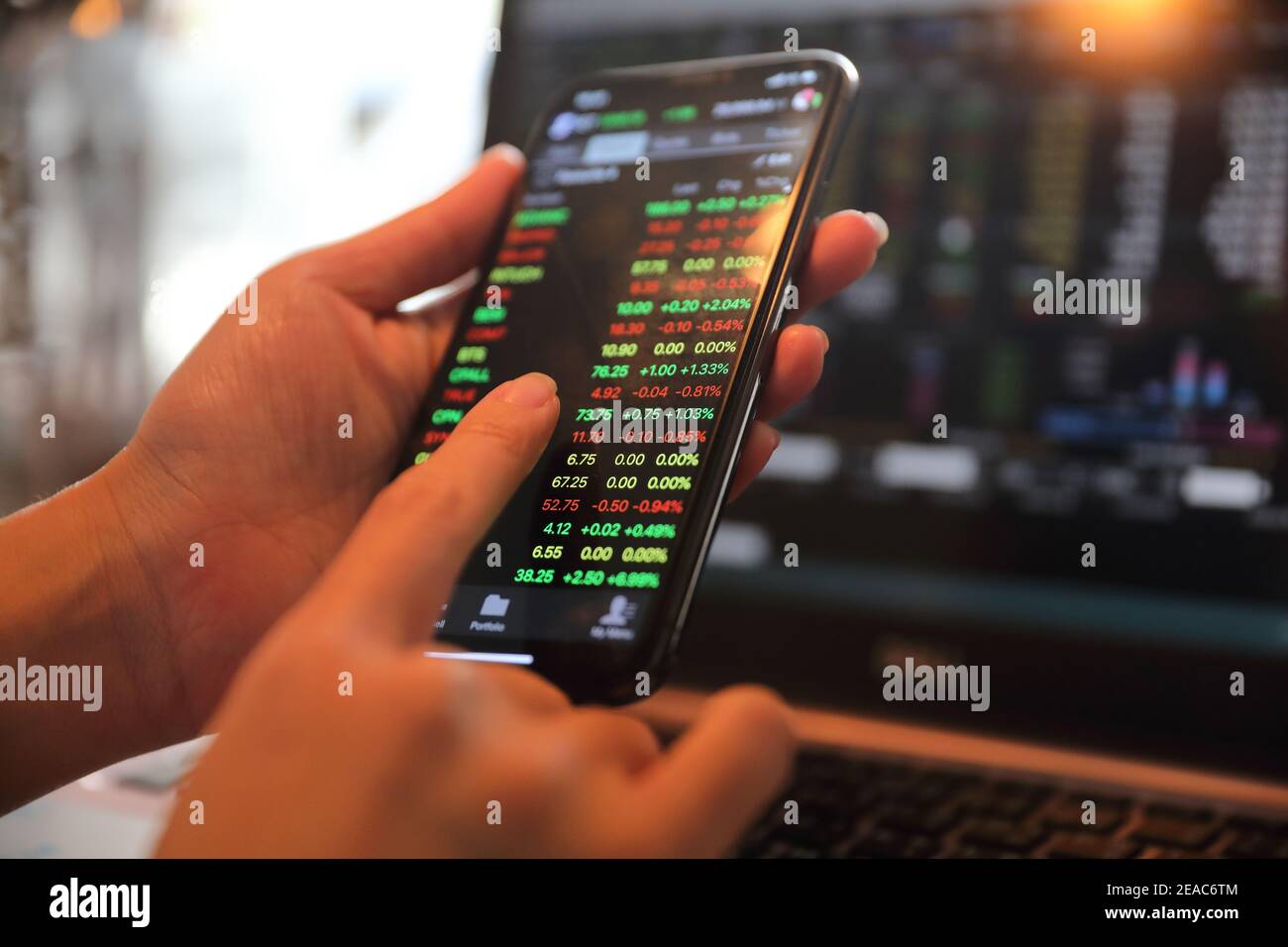 Female hand with smartphone trading stock online in coffee shop ...