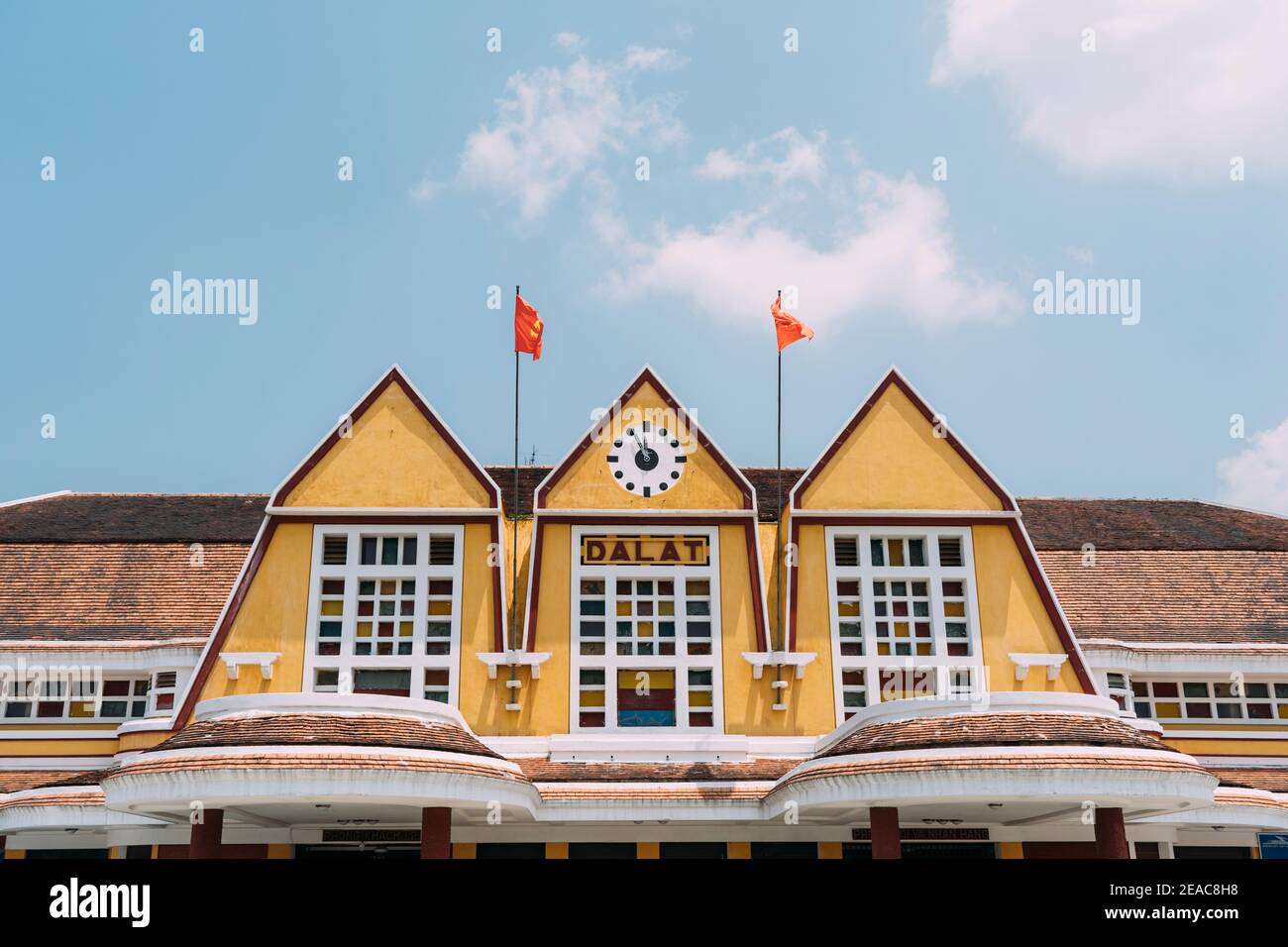 Old yellow train station sign with clock and flags in Dalat, Vietnam ...