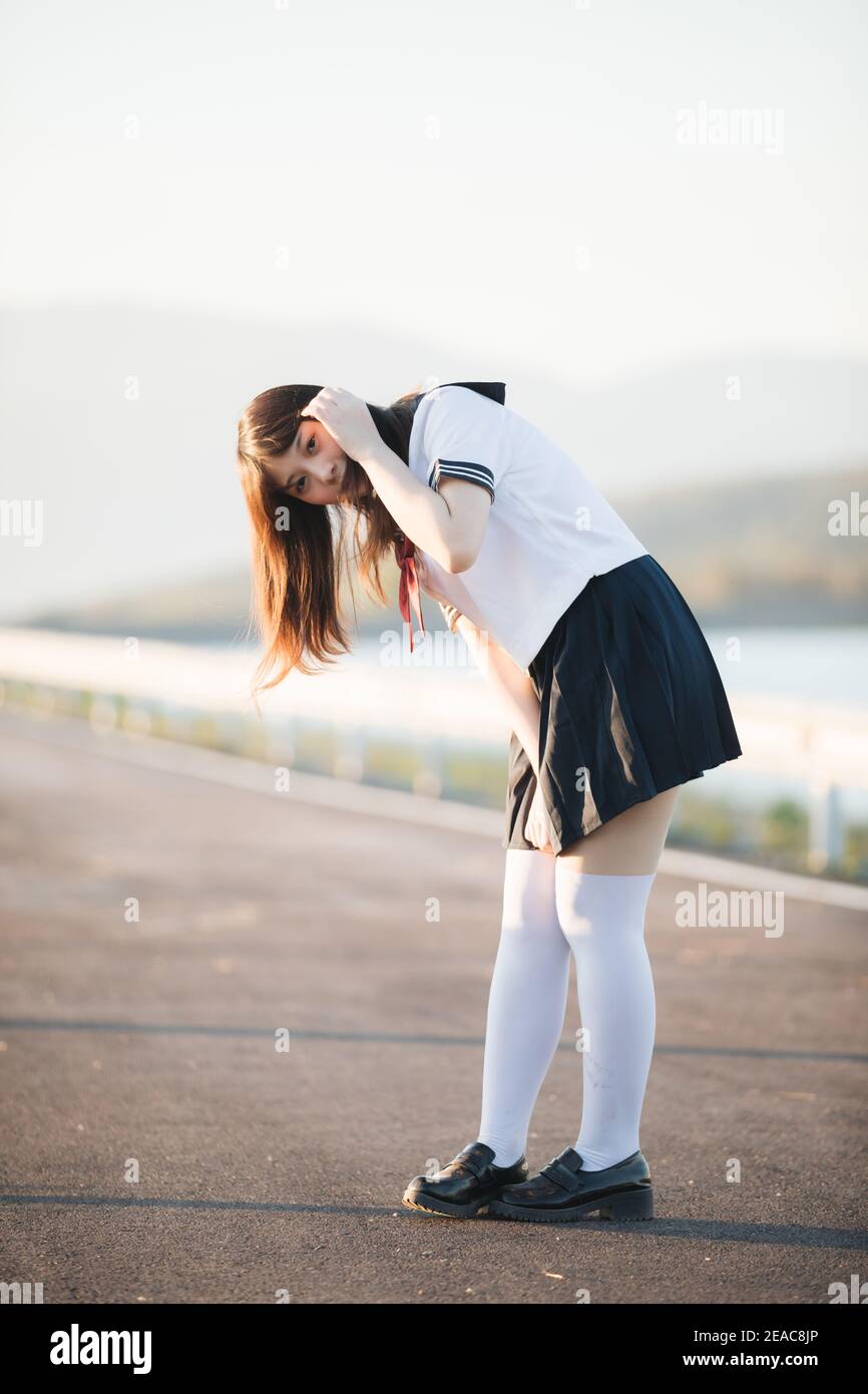 Portrait of Japanese school girl uniform smile with walkway and river ...