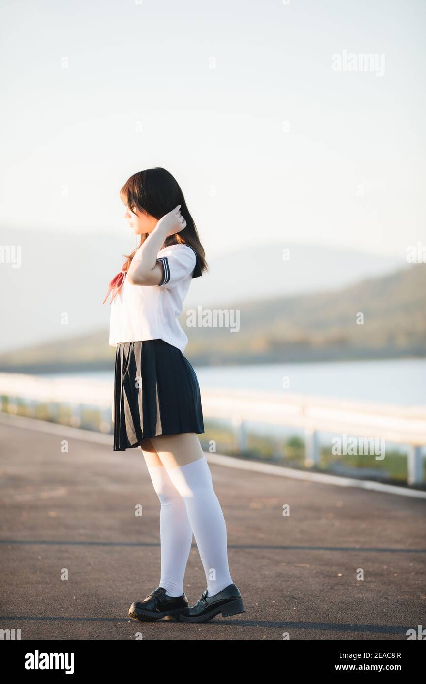 Portrait of Japanese school girl uniform smile with walkway and river ...