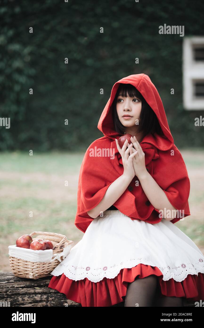 Portrait young woman with Little Red Riding Hood costume in green tree ...