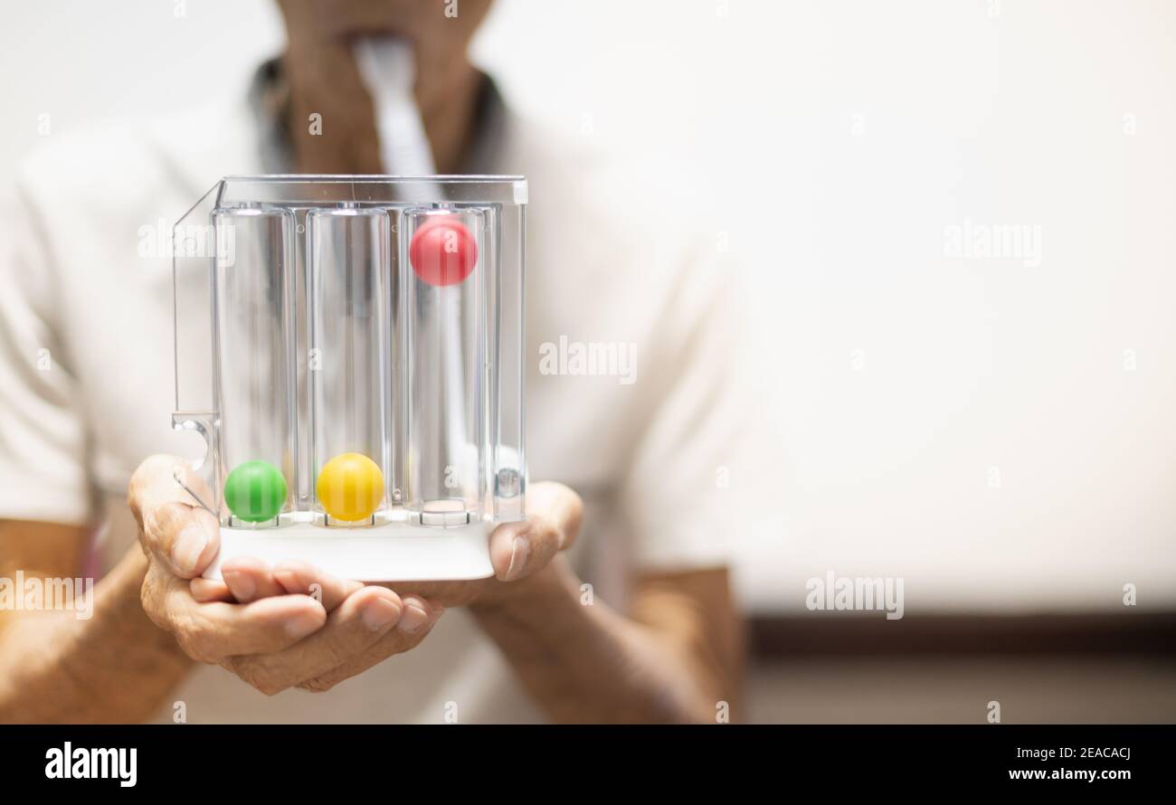 The old patient hand holding the Tri-ball incentive spirometry is ...