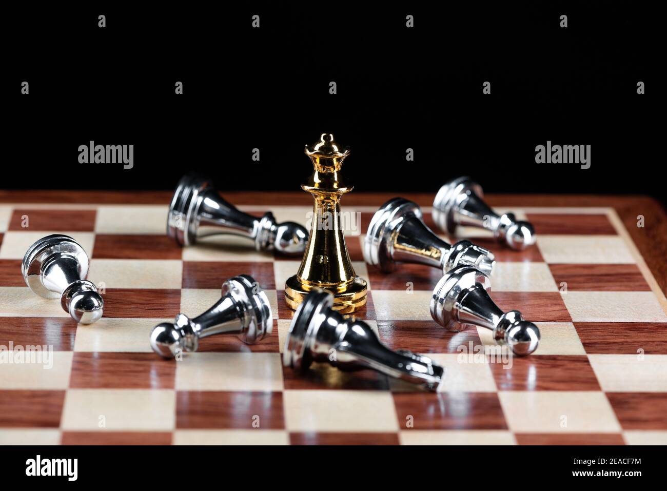 Gold queen chess defeats silver figures on board Stock Photo - Alamy