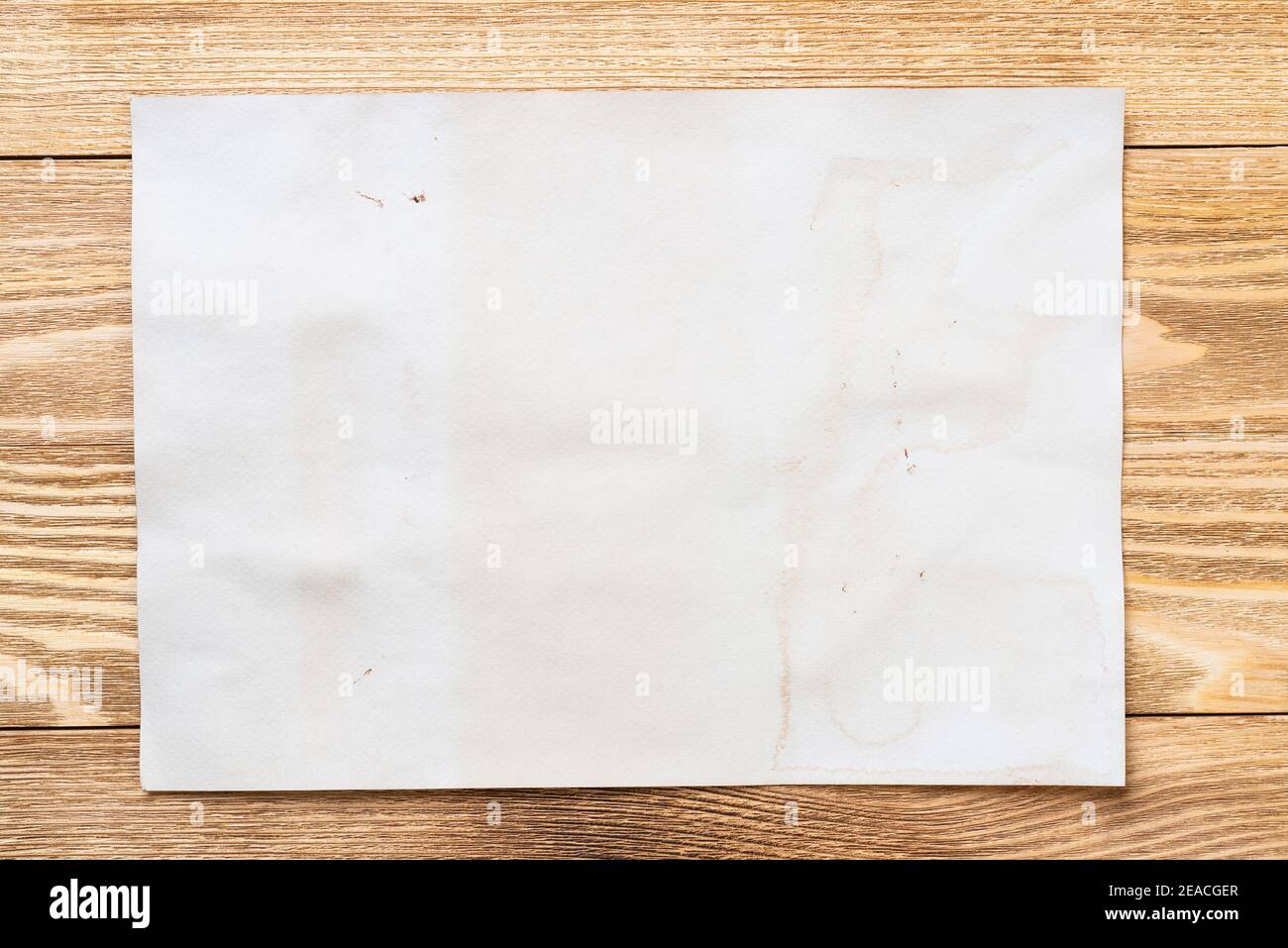 Sheet of paper lying on wooden table Stock Photo - Alamy