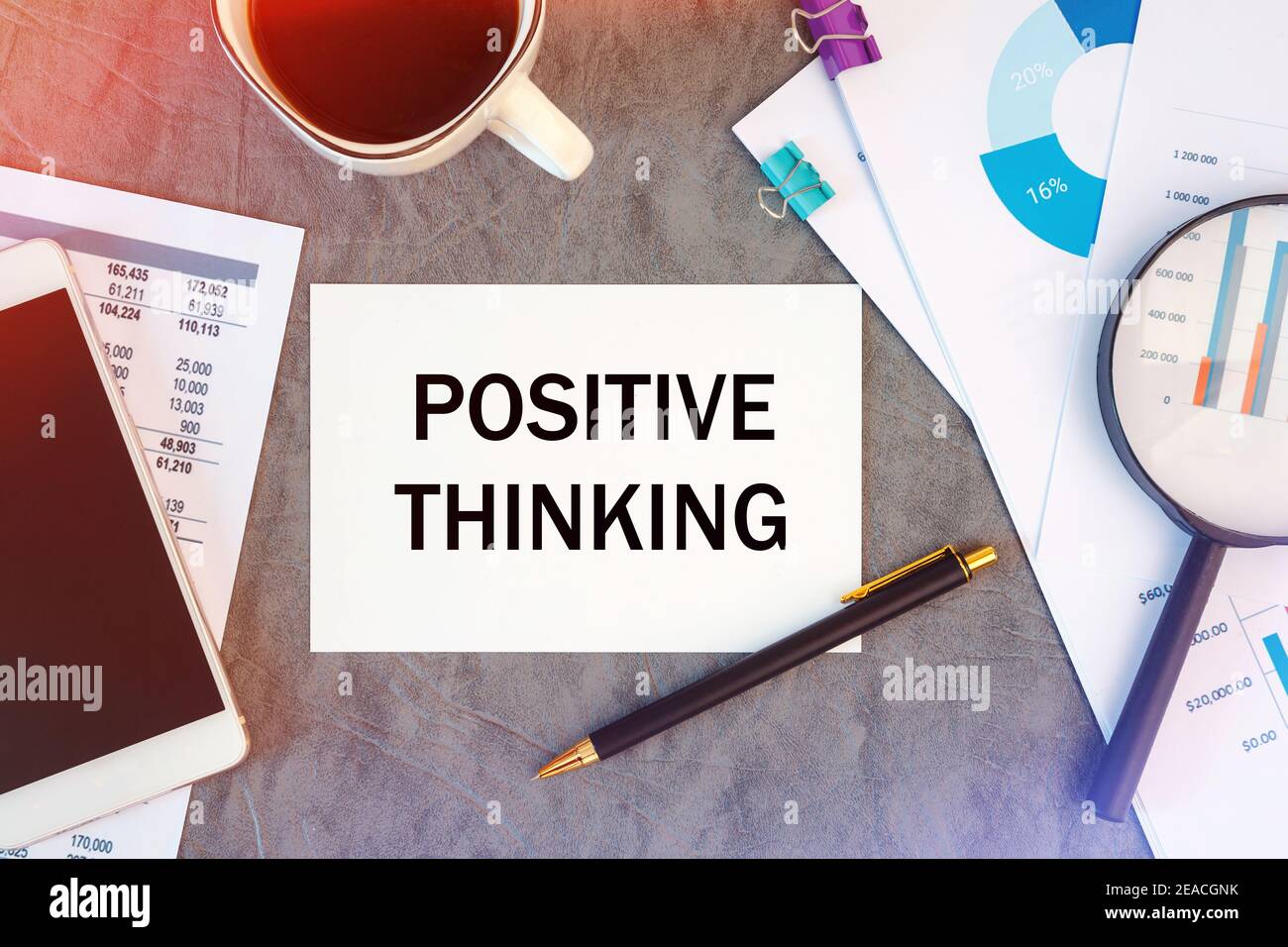 Positive Thinking is written in a document on the office desk with ...