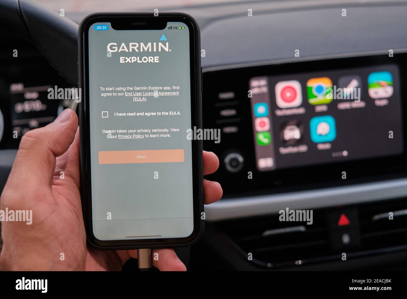 Garmin explore logo on the screen of smart phone in mans hand on the ...