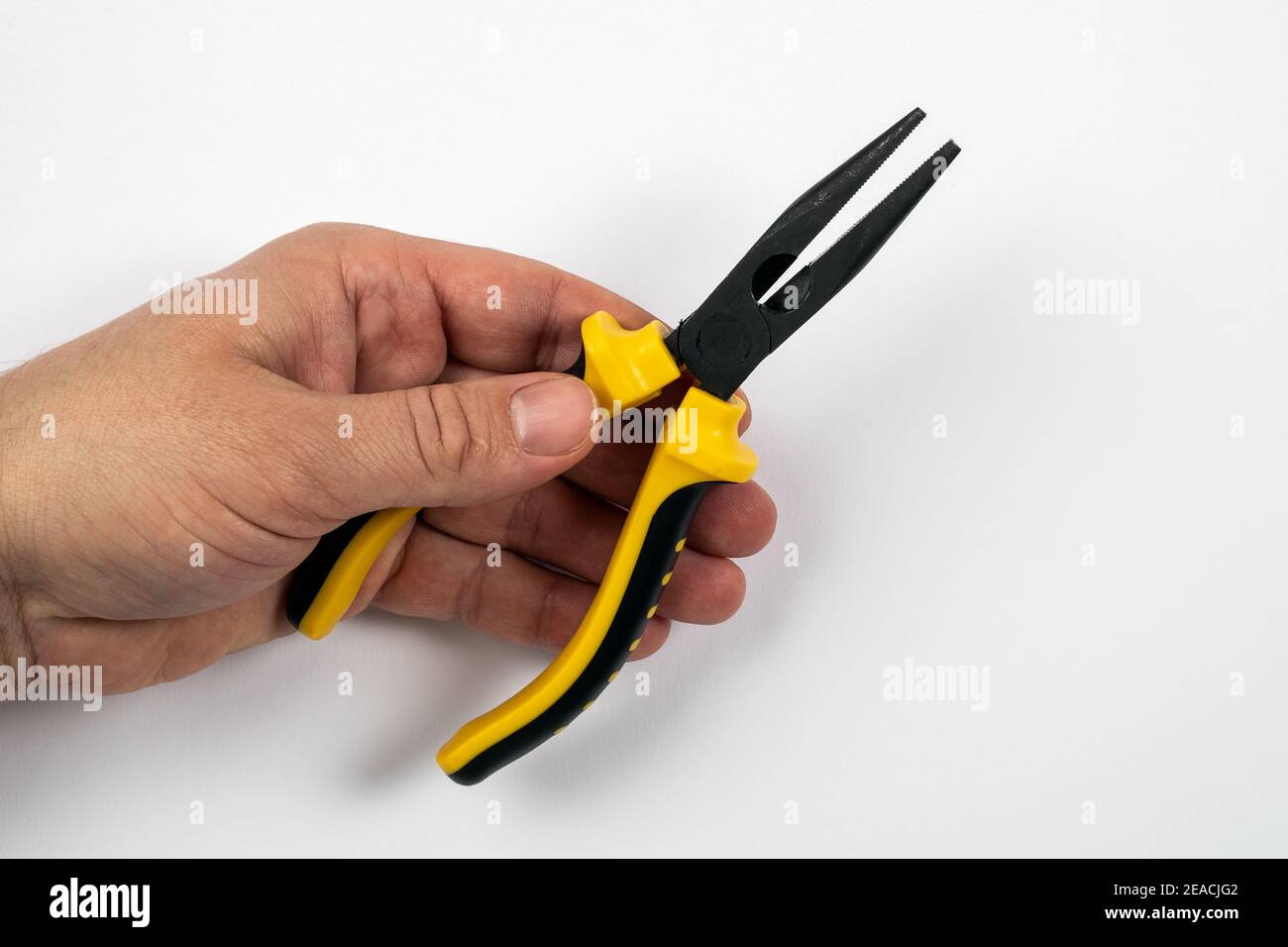 Yellow pliers in a man's hand on a white background Stock Photo - Alamy