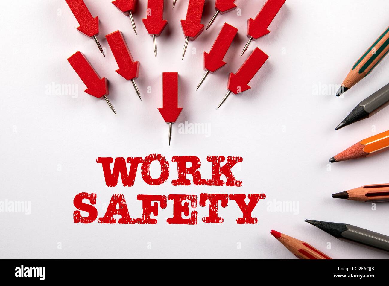 Work Safety concept. Red arrows and colored pencils on a white ...